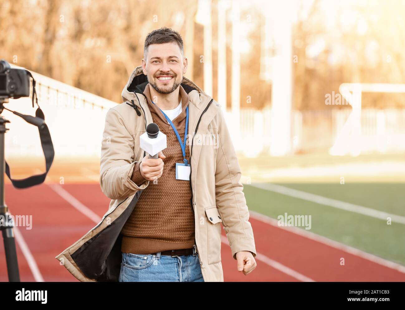 Male reporter with microphone at the stadium Stock Photo - Alamy
