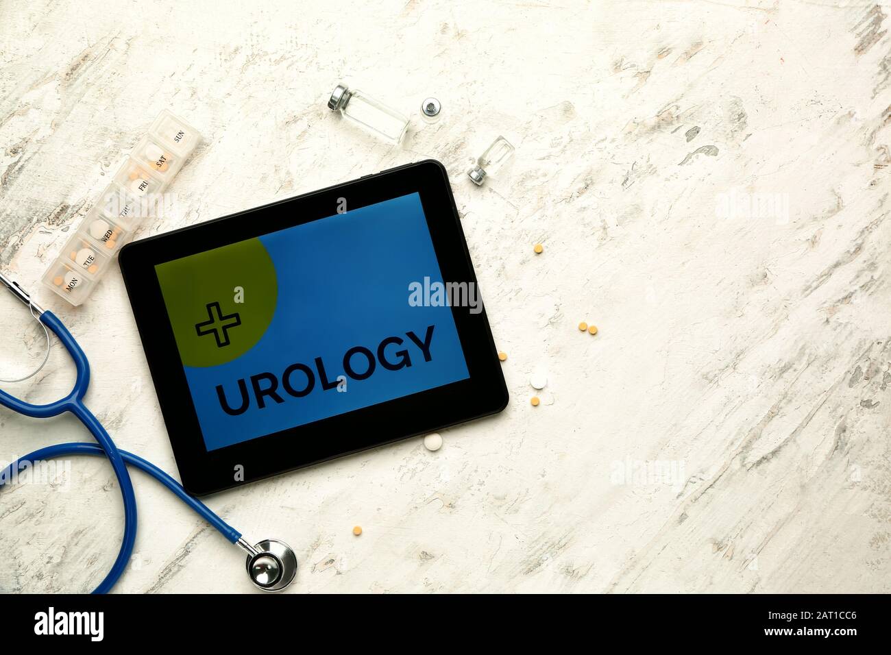 Tablet computer with word UROLOGY on screen, stethoscope and medicines ...