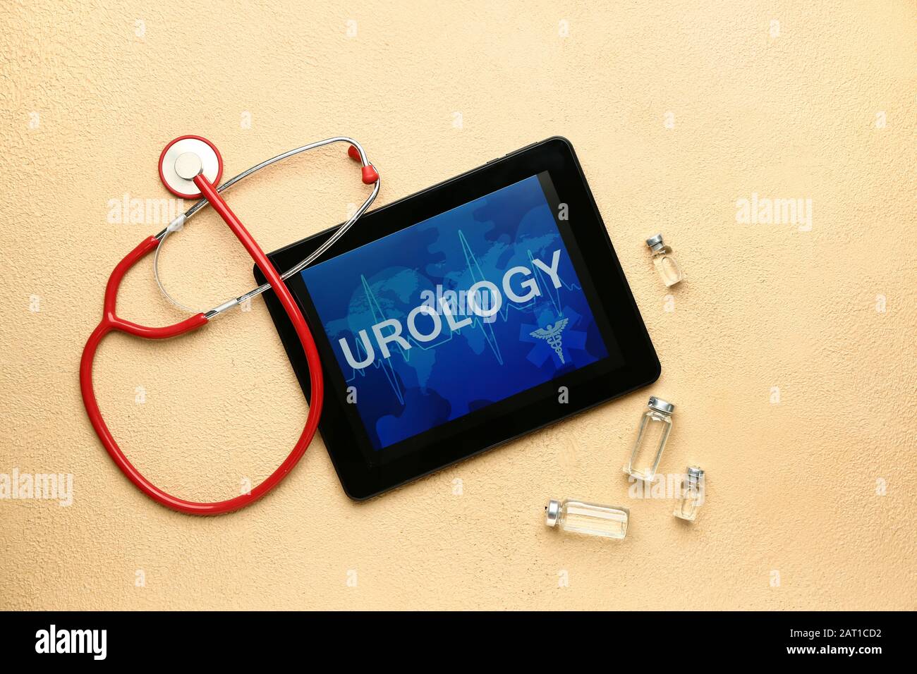 Tablet computer with word UROLOGY on screen, stethoscope and medicines ...
