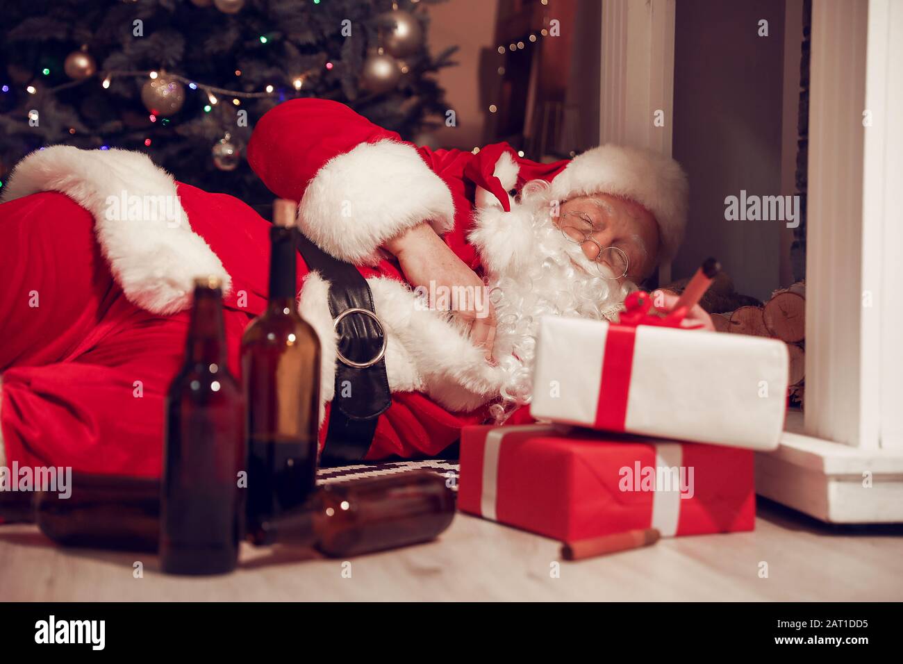 Funny drunk Santa Claus lying on floor near fireplace Stock Photo - Alamy