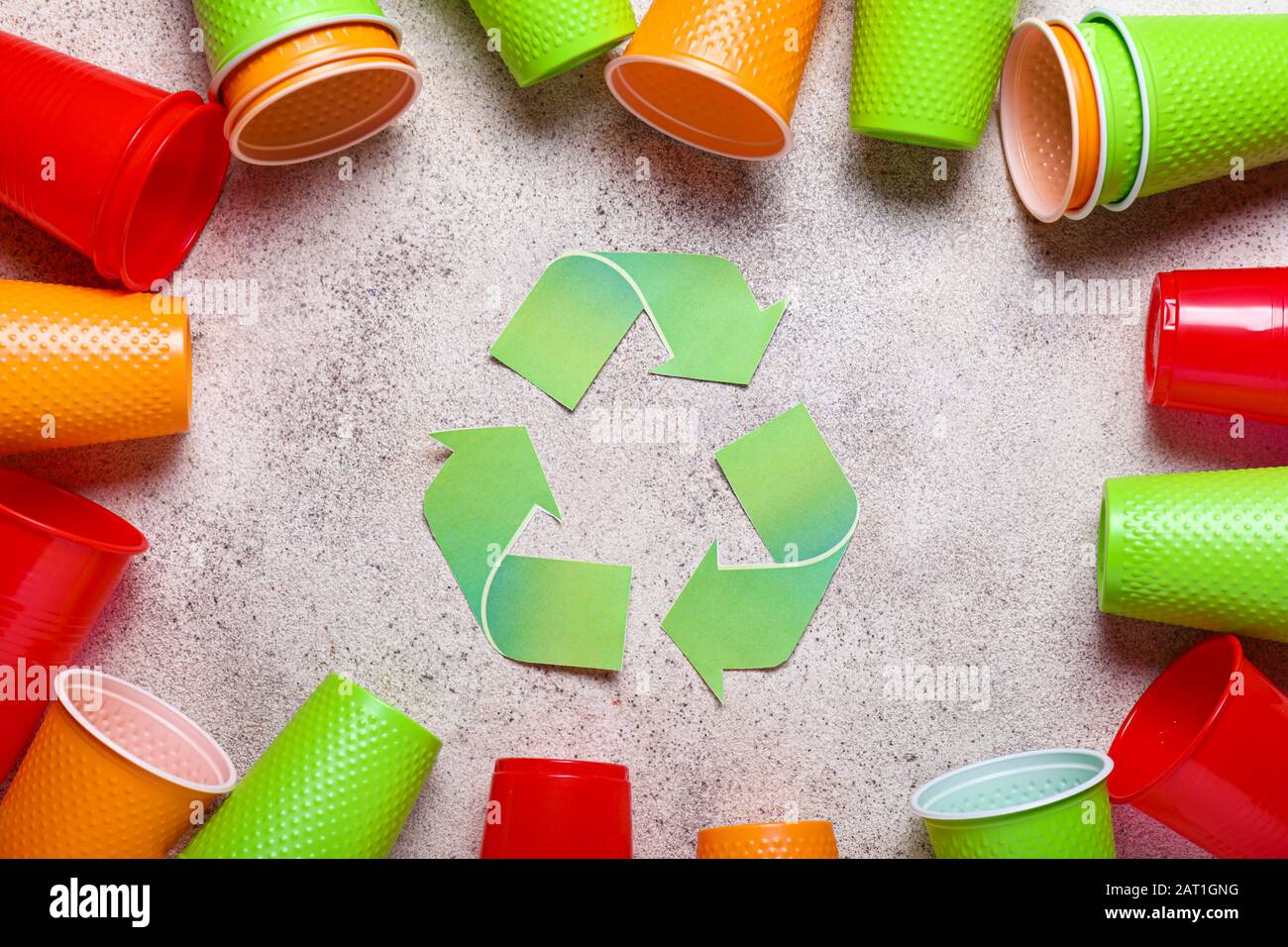 Plastic cups and recycling symbol on light background Stock Photo - Alamy