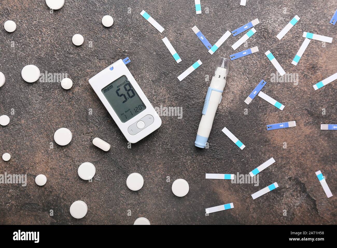 Pills, glucometer and lancet pen on grey background. Diabetes concept ...