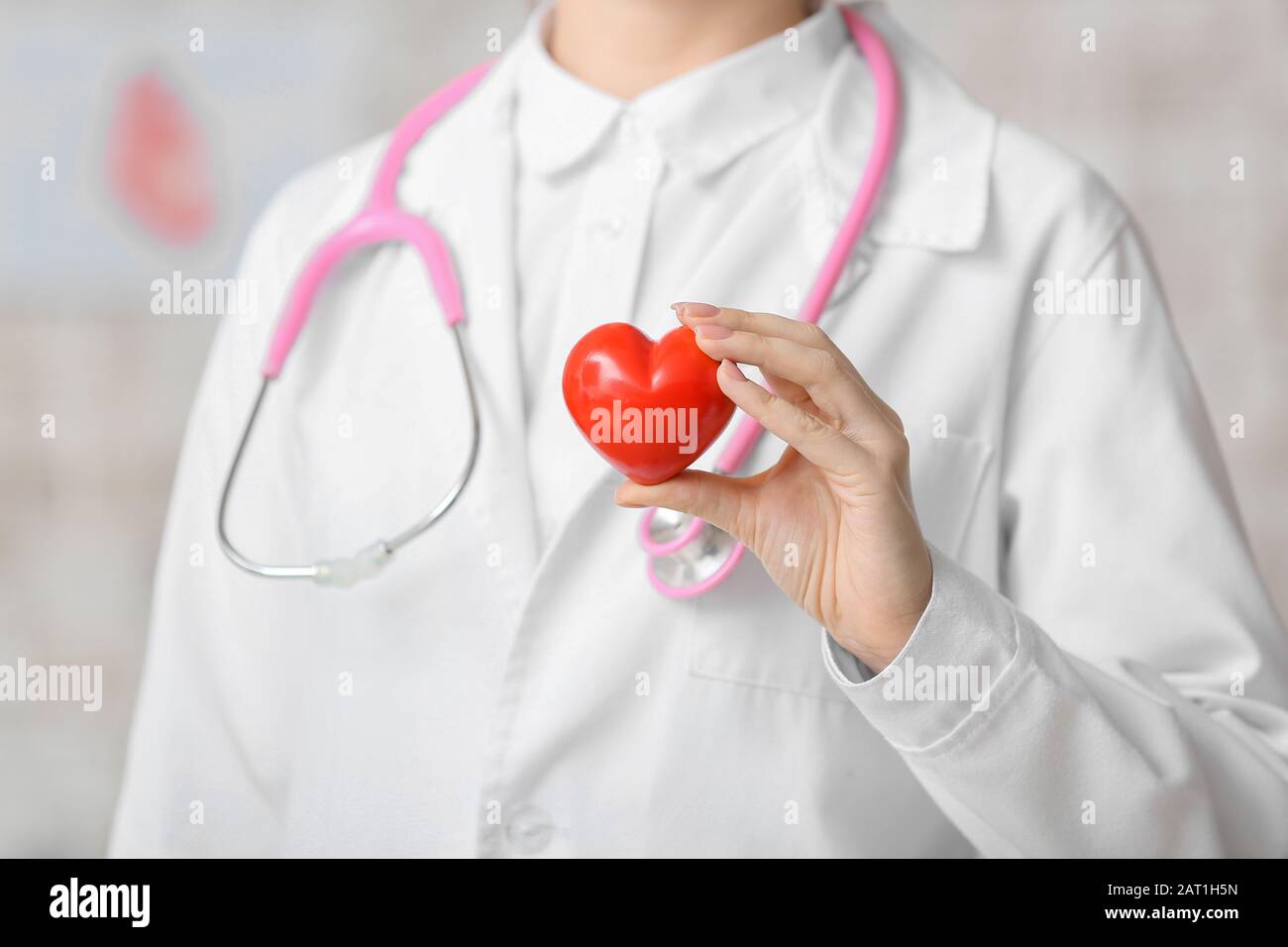 Female cardiologist with red heart on light background Stock Photo - Alamy