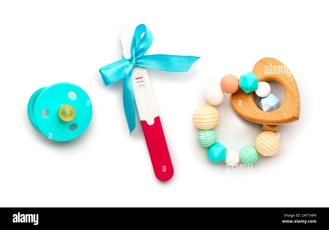 Pregnancy test, toy and pacifier on white background Stock Photo - Alamy