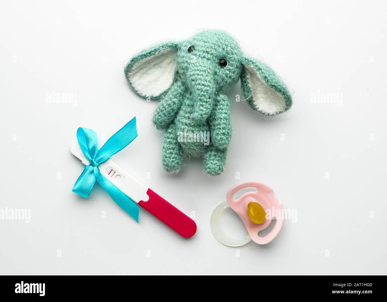 Pregnancy test, toy and pacifier on white background Stock Photo - Alamy