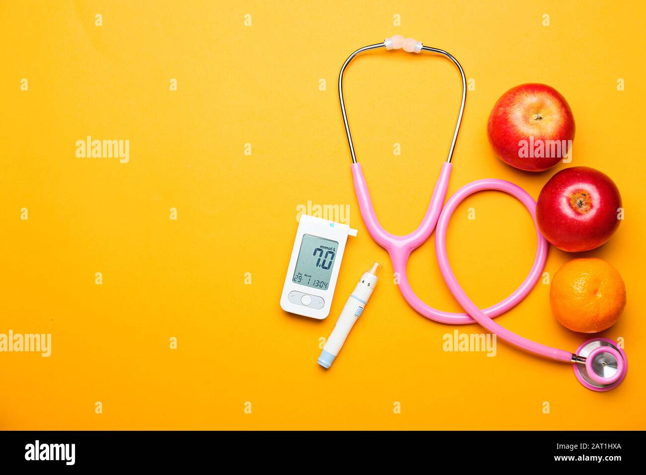 Digital glucometer, lancet pen, stethoscope and fruits on color ...