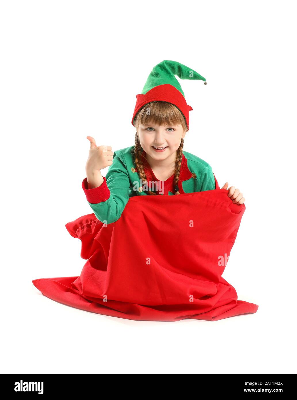 Little elf kid sitting in Santa Claus bag and showing thumb-up gesture ...