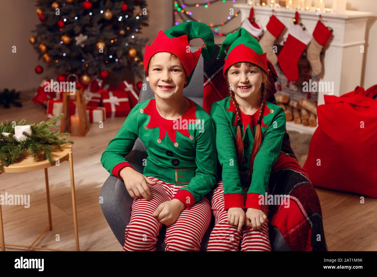 Little children in costume of elf in room decorated for Christmas Stock ...
