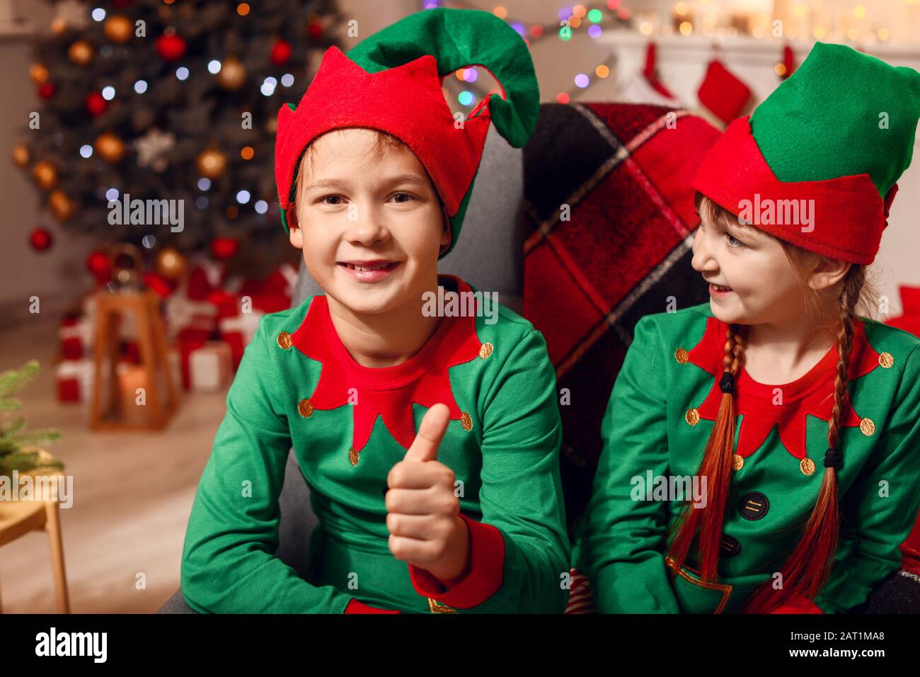 Little children in costume of elf in room decorated for Christmas Stock ...