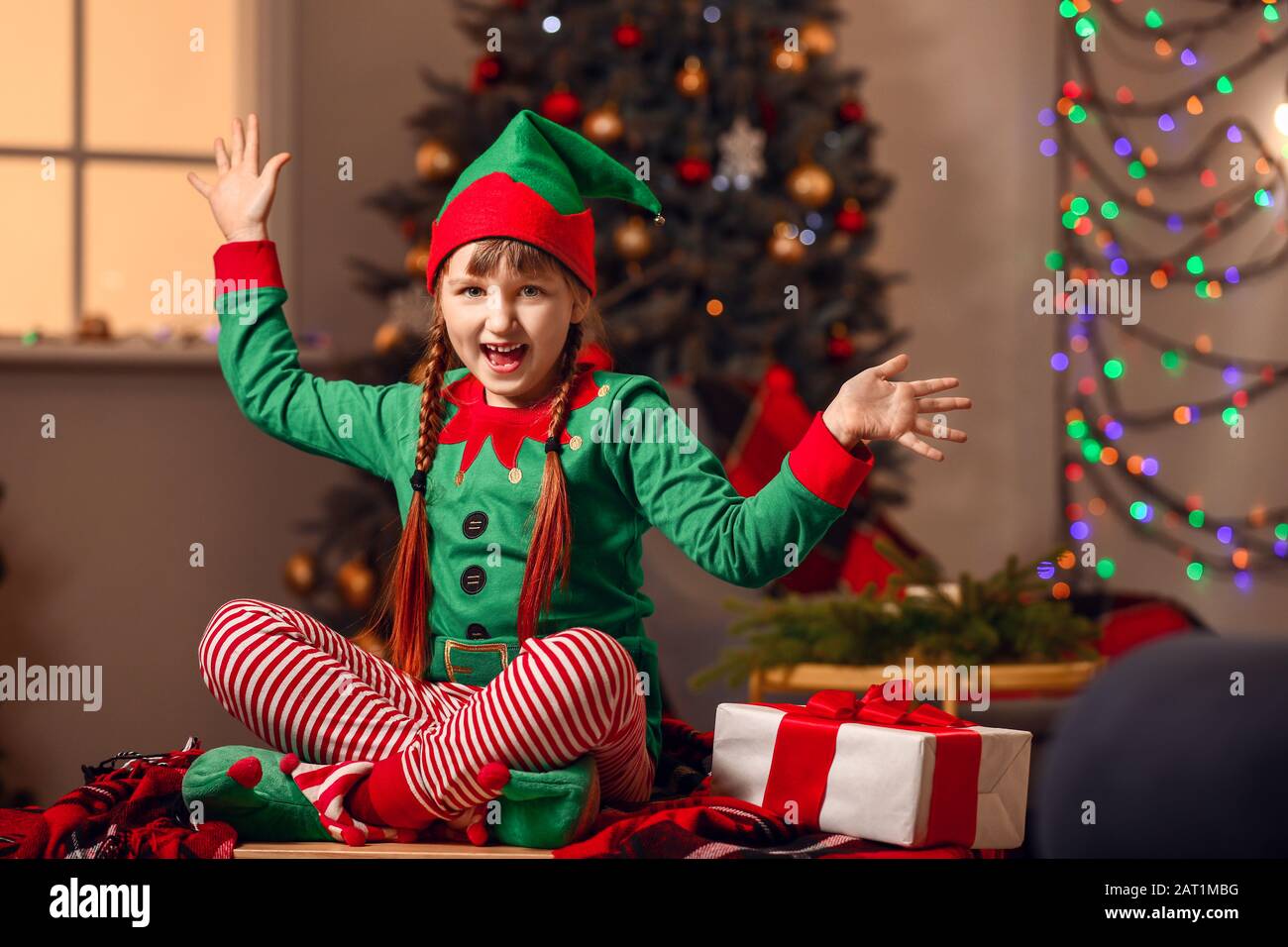 Little girl in costume of elf in room decorated for Christmas Stock ...