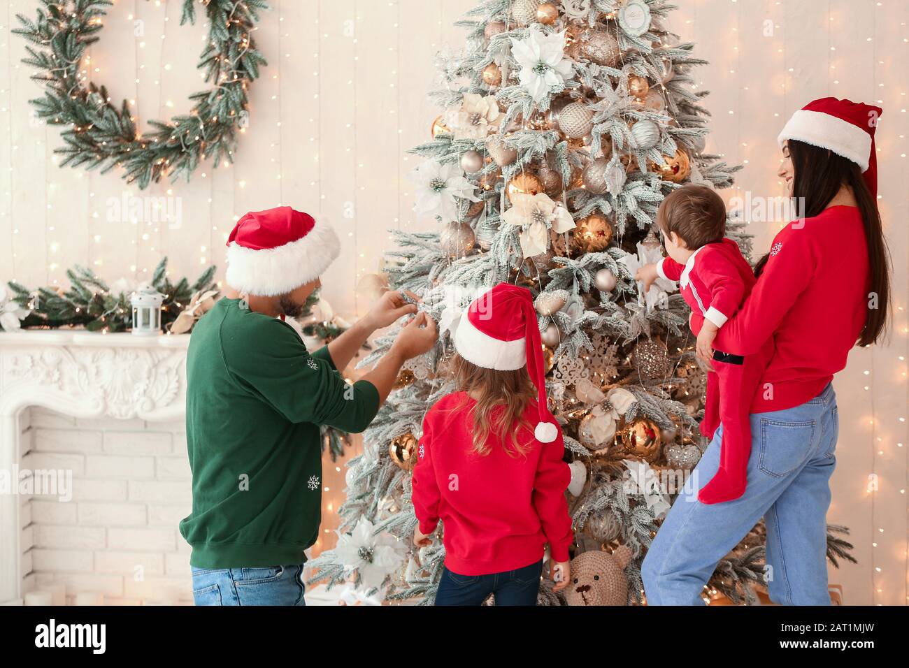 Happy family decorating Christmas tree at home Stock Photo - Alamy