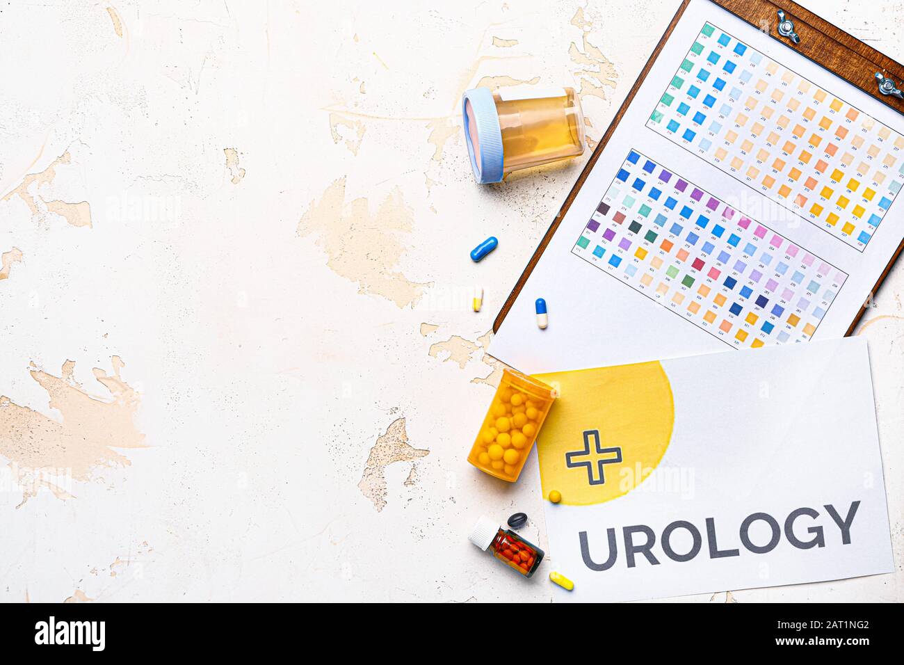 Paper sheet with text UROLOGY, pills and urine sample on light ...