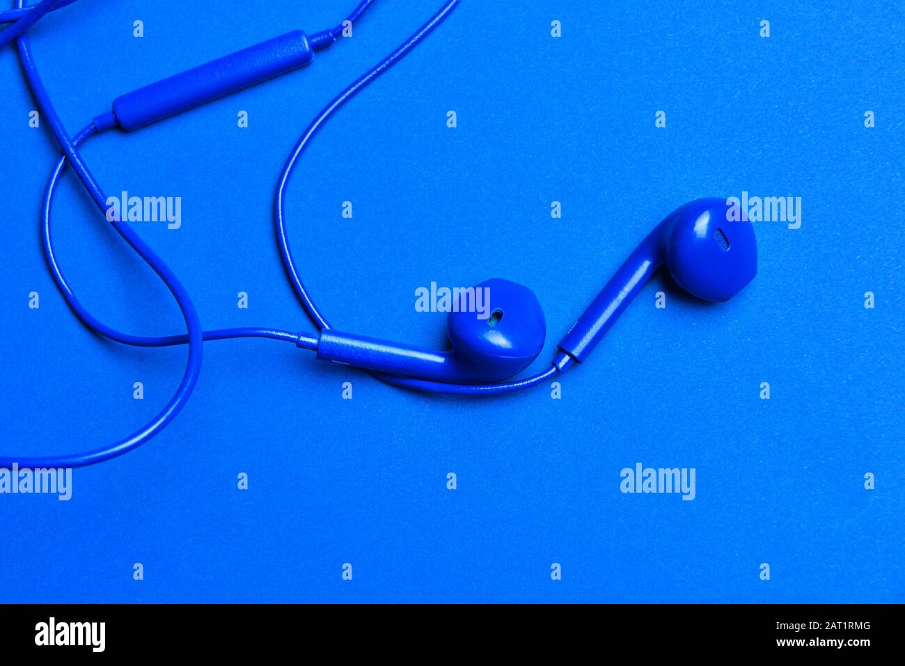 Blue earphones on color background Stock Photo - Alamy