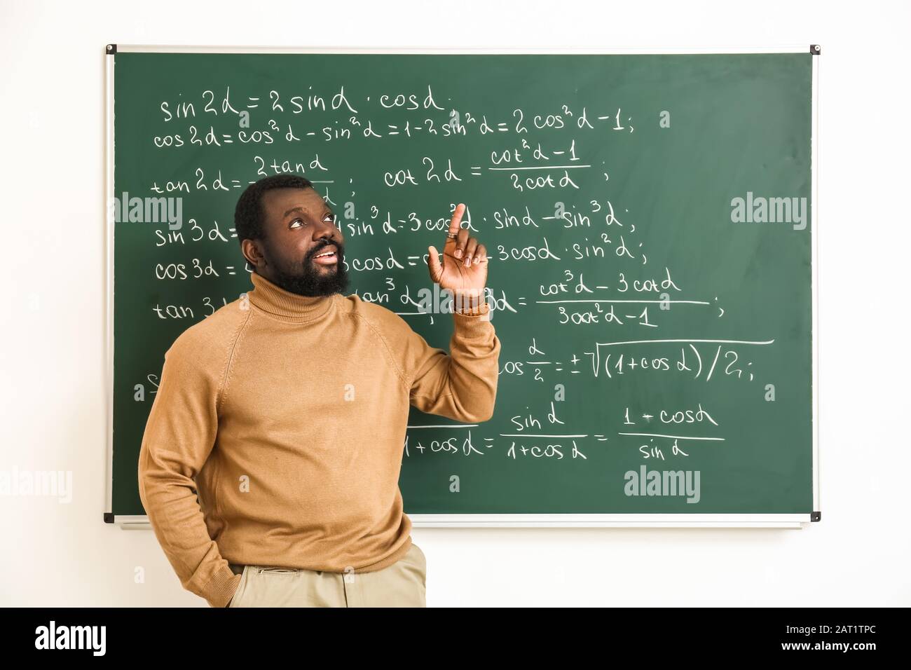African-American math teacher near blackboard in classroom Stock Photo ...