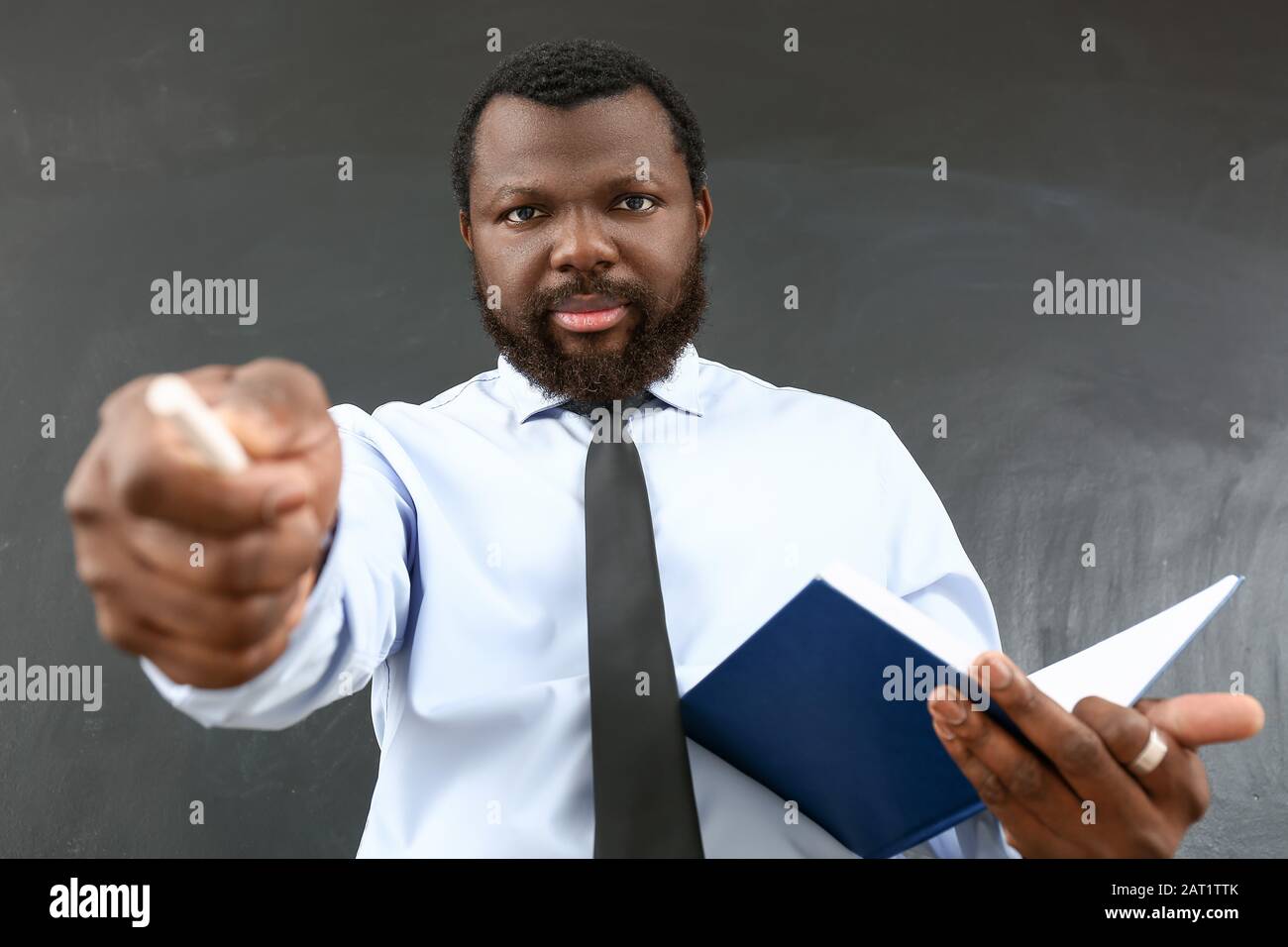 Angry African-American teacher near blackboard in classroom Stock Photo ...