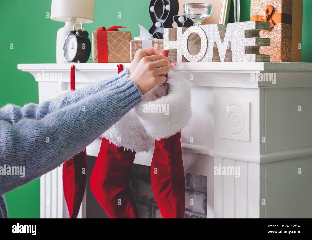 Woman hanging socks on fireplace at home Stock Photo - Alamy