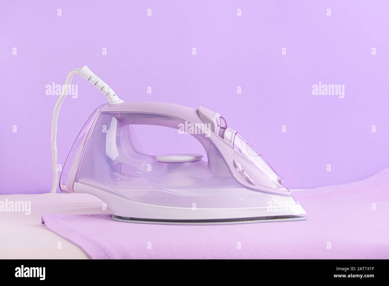 Electric iron and board on color background Stock Photo - Alamy