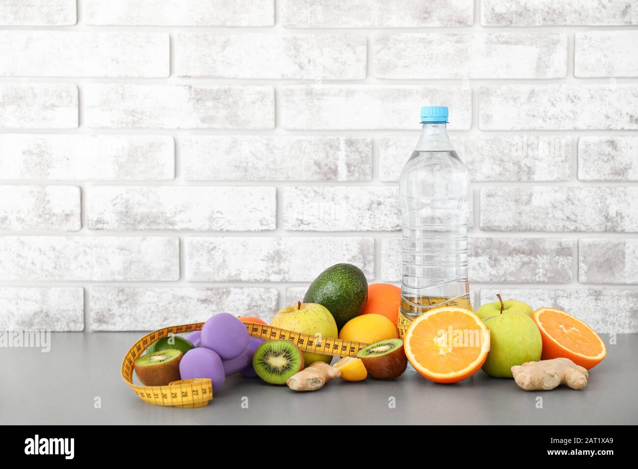 Different healthy food with measuring tape and dumbbells on table. Diet ...