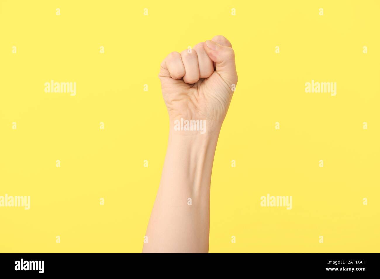 Hand of woman with clenched fist on color background Stock Photo - Alamy