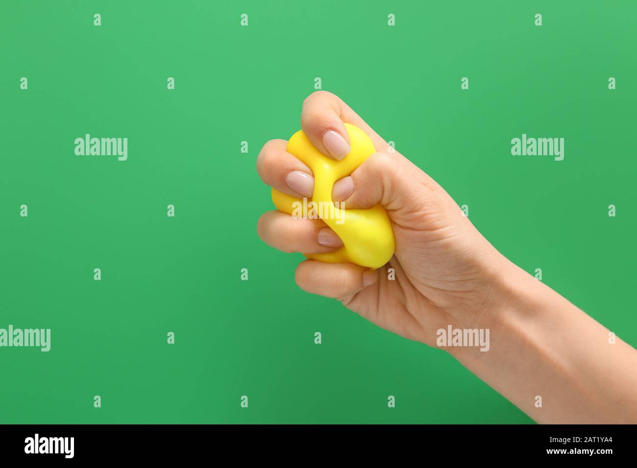 Hand squeezing stress ball on color background Stock Photo - Alamy