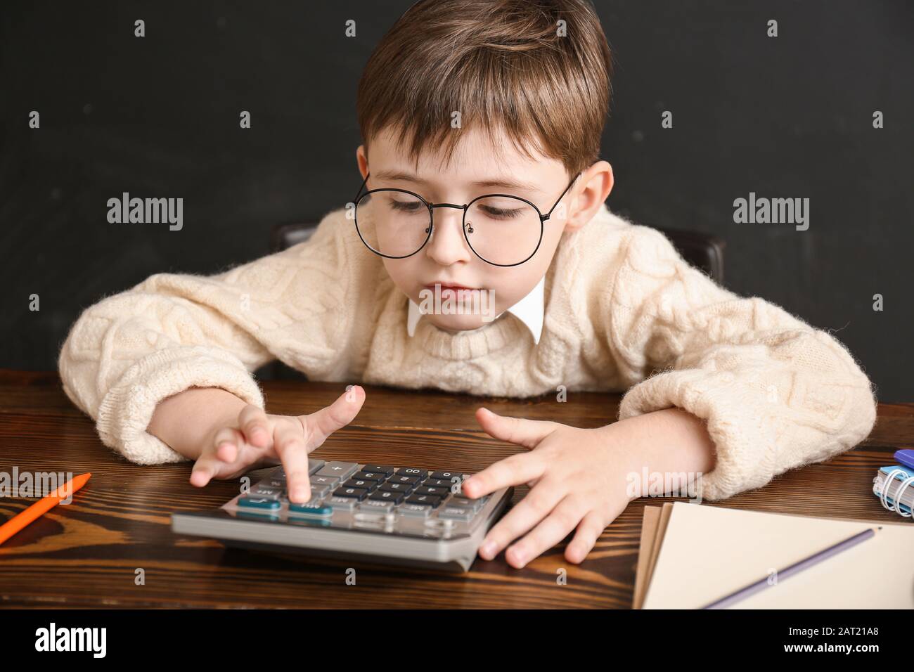 Little schoolboy doing task in classroom Stock Photo - Alamy