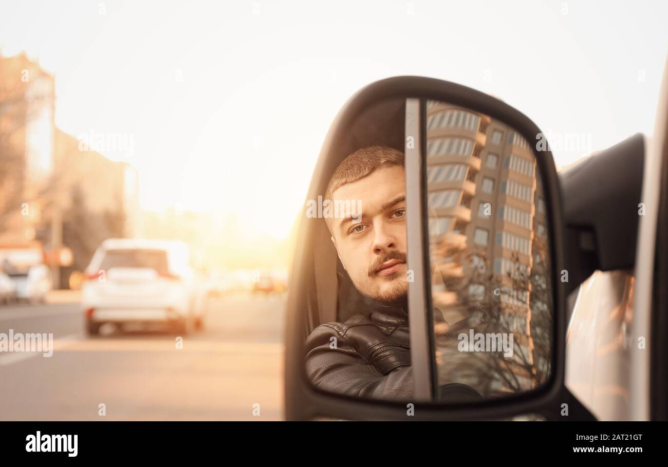 Reflection of driver in car side mirror Stock Photo - Alamy