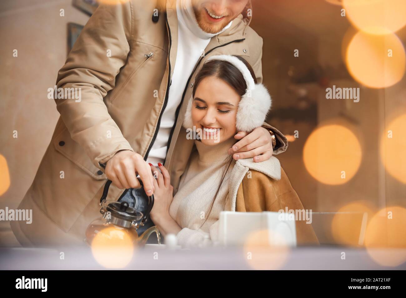 Happy young couple sitting in cafe, view through glass window Stock ...