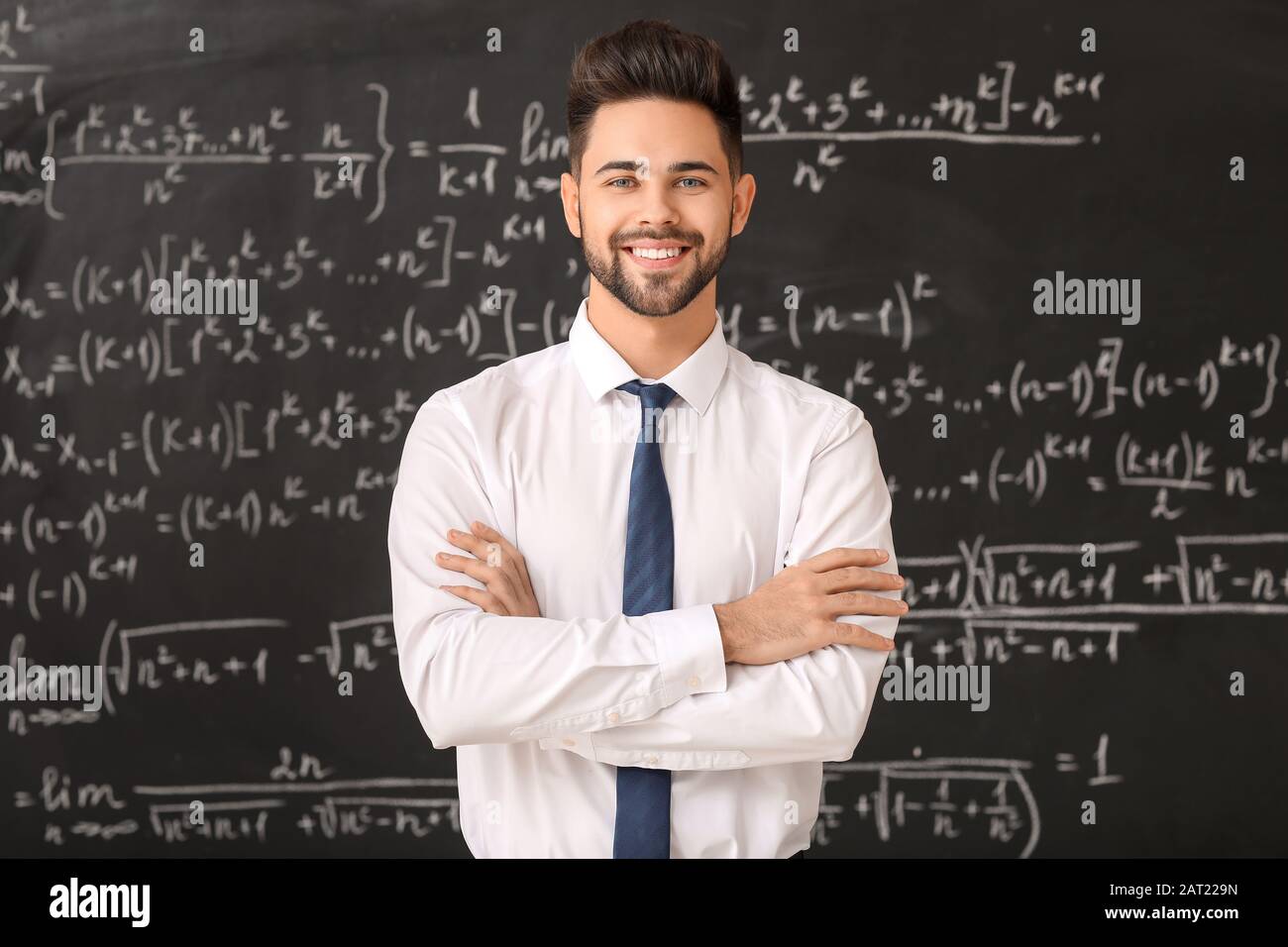 Male teacher near blackboard in classroom Stock Photo - Alamy