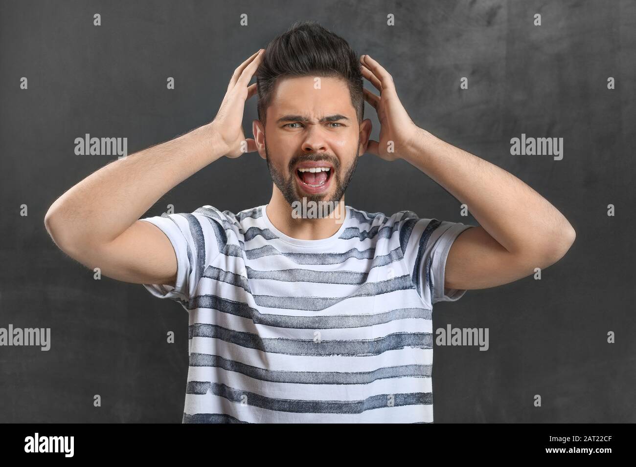 Stressed male student near blackboard in classroom Stock Photo - Alamy