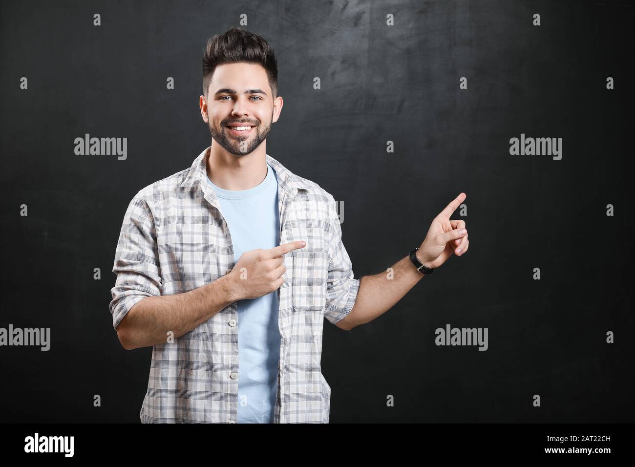 Male student pointing at blackboard in classroom Stock Photo - Alamy