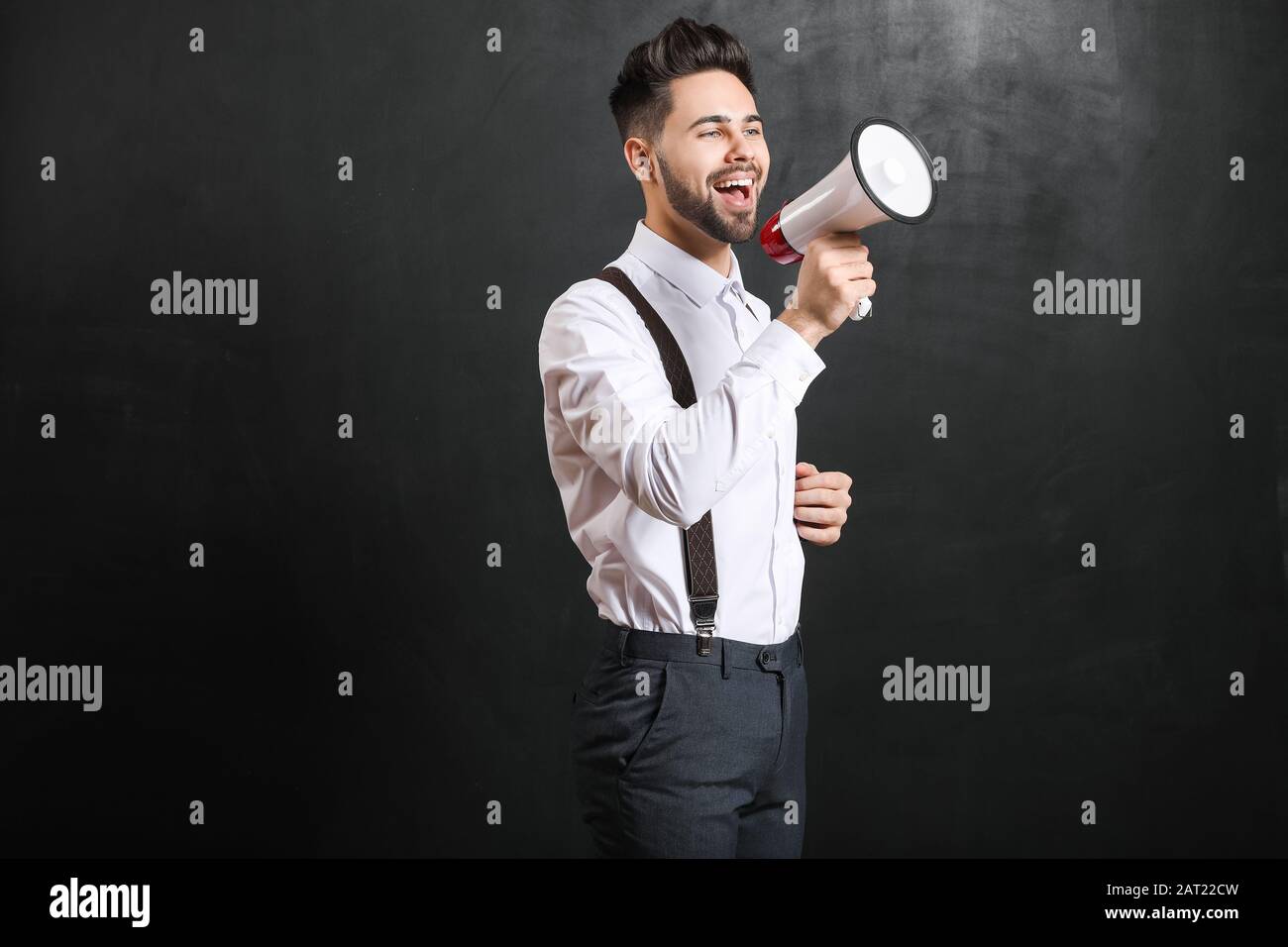 Male teacher with megaphone near blackboard in classroom Stock Photo ...