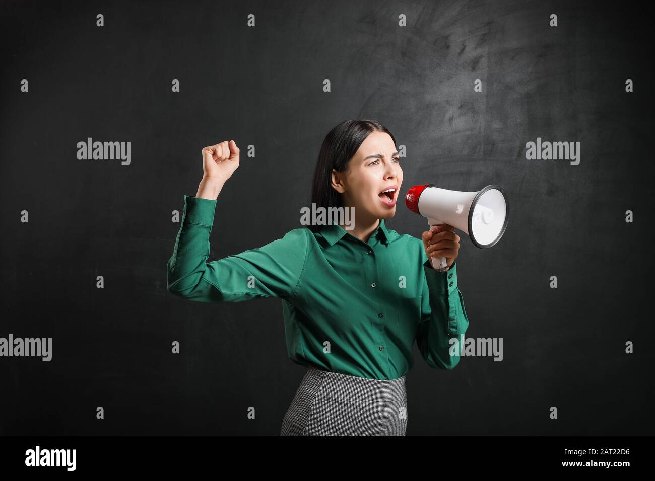 Female teacher with megaphone near blackboard in classroom Stock Photo ...