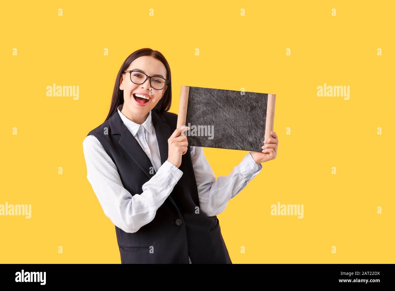 Female teacher with chalkboard on color background Stock Photo - Alamy
