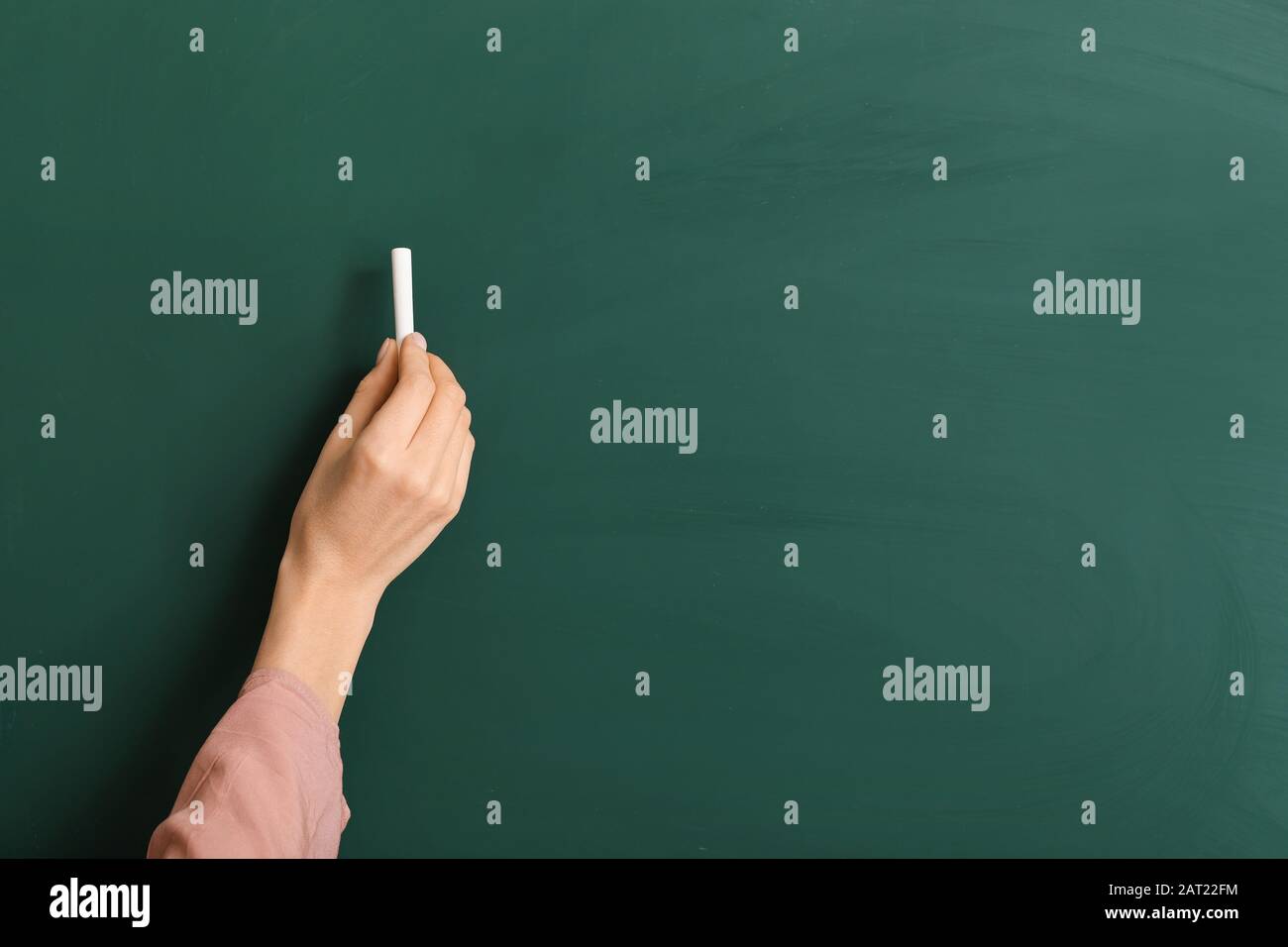 Female teacher writing on blackboard in classroom Stock Photo - Alamy