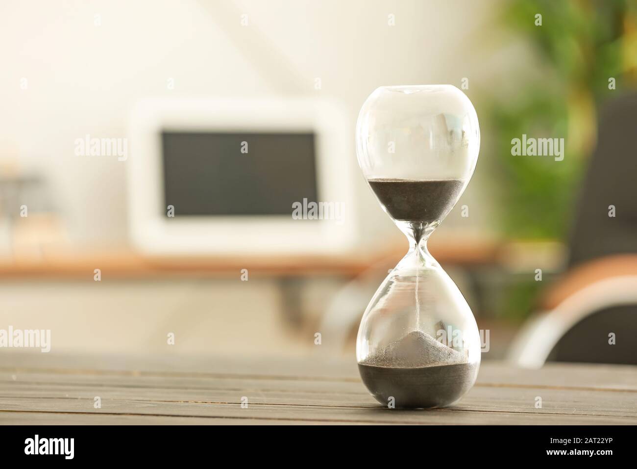 Hourglass on table in office. Time management concept Stock Photo - Alamy