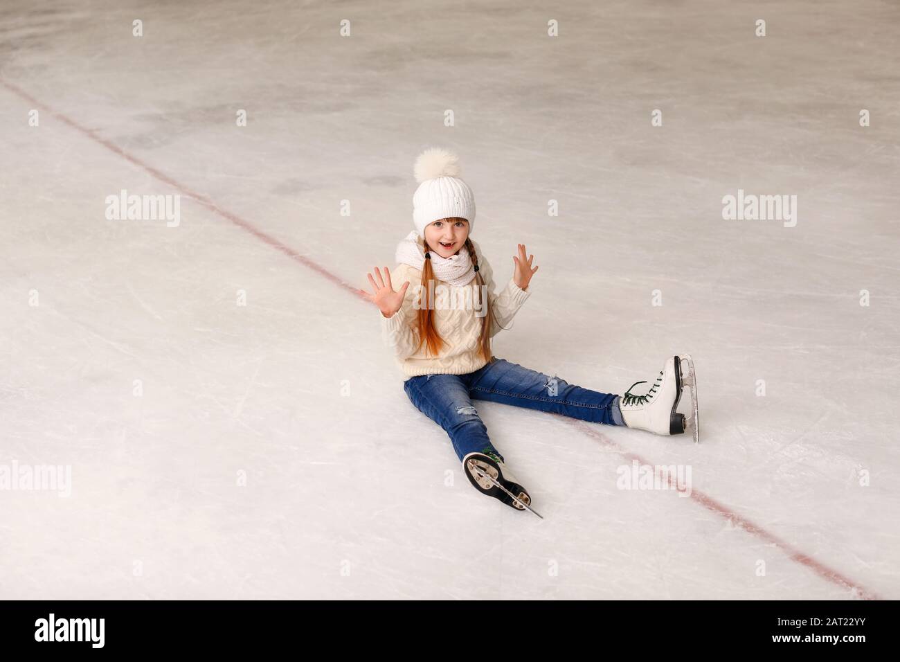 Cute little girl after falling on skating rink Stock Photo - Alamy