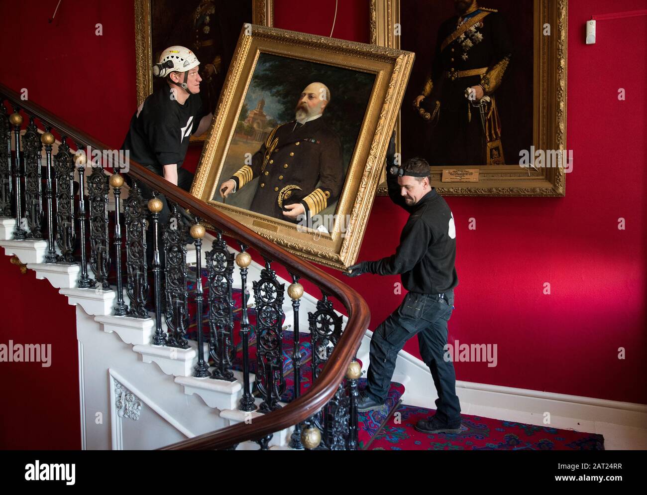 Workmen carry a painting of Edward VII by artist Emile Fuchs down some ...