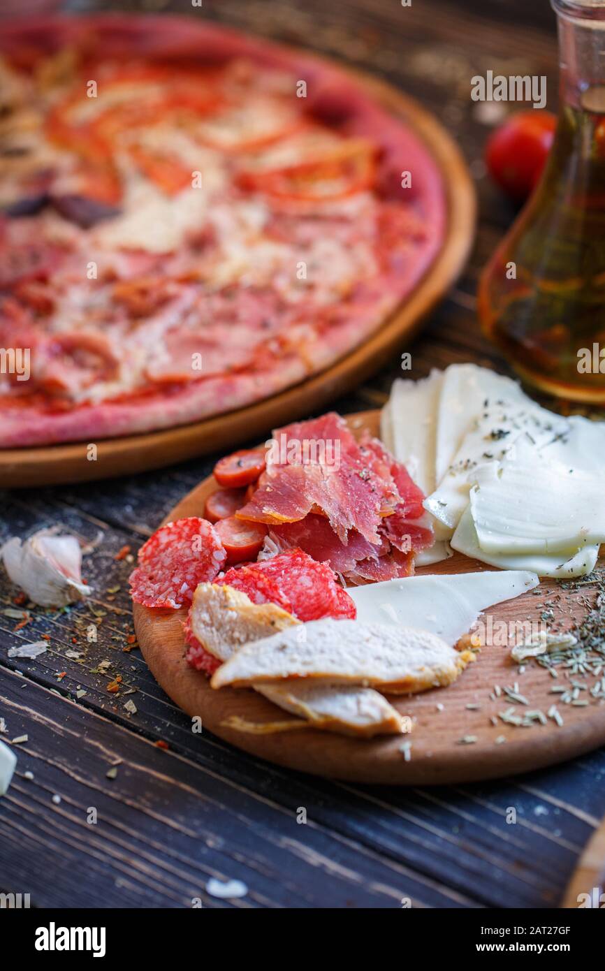 Traditional Italian pizza on a dark table with ingredients Stock Photo ...