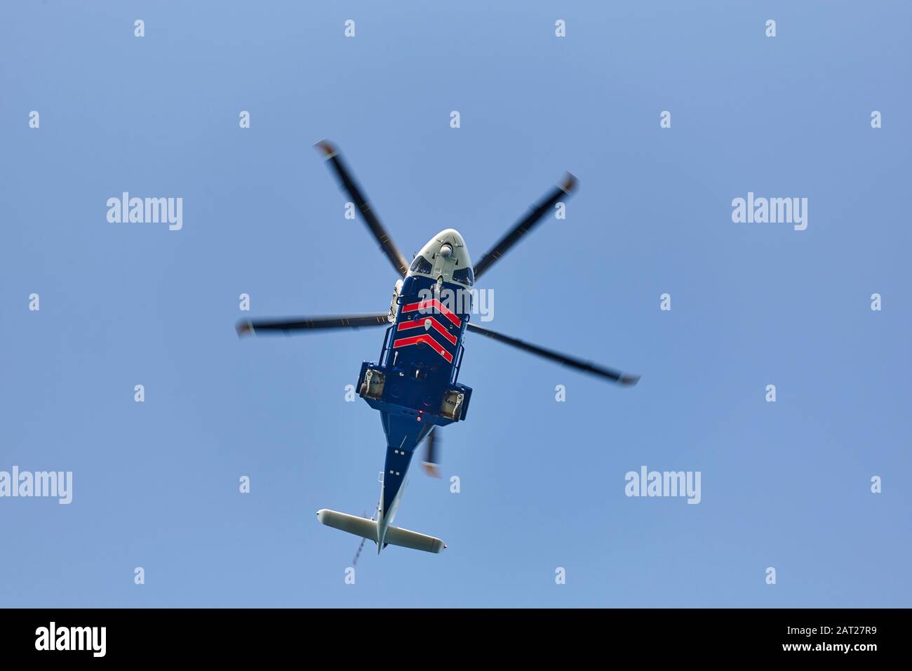 Helicopter flying under a blue sky from below. Air transport Stock ...