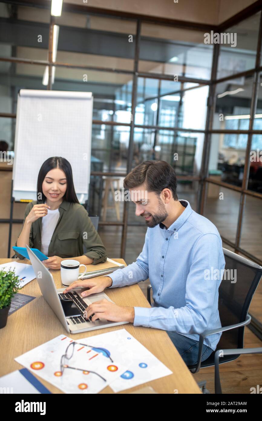 Two coworkers sitting at the table and working together Stock Photo - Alamy