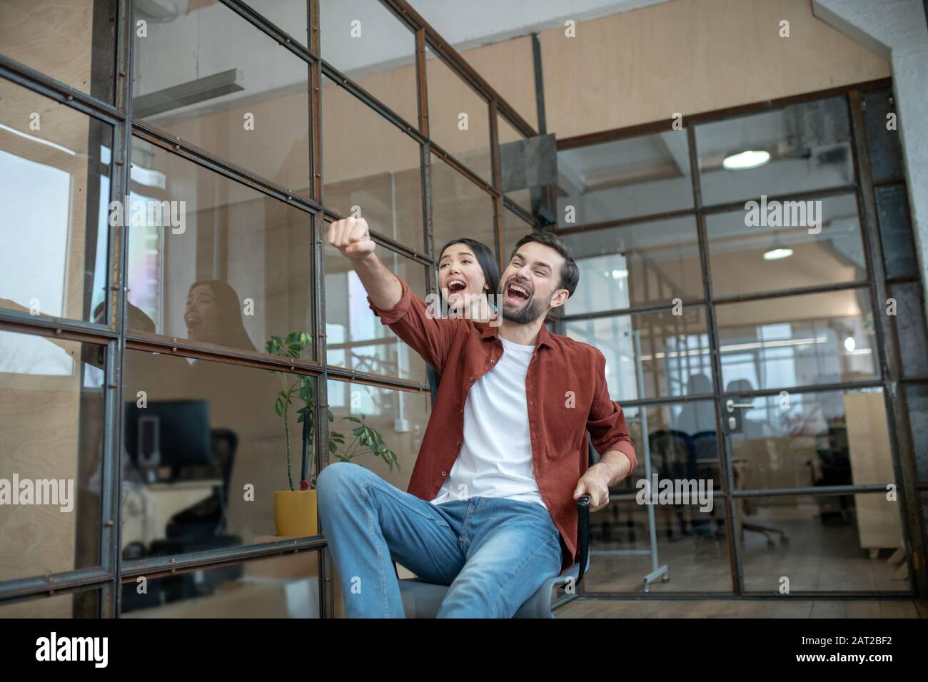 Young couple having fun in the office corridor Stock Photo - Alamy