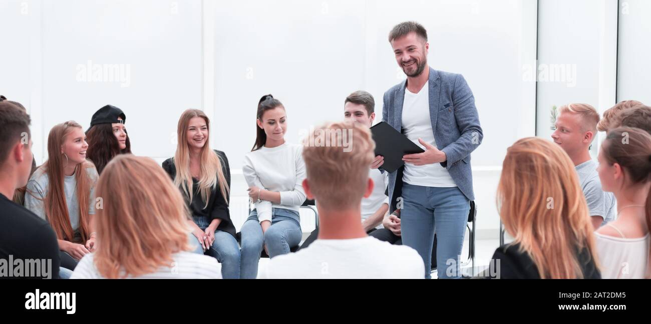 business coach standing in a circle of young people Stock Photo - Alamy