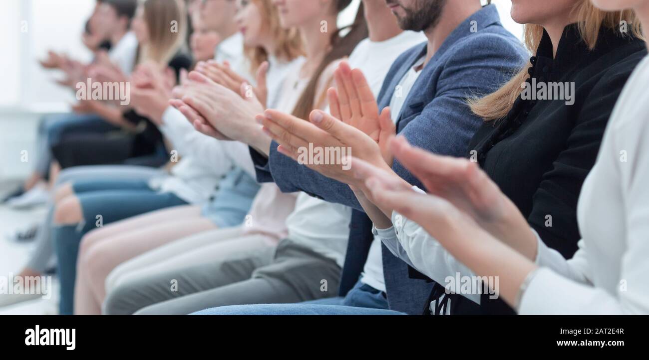 group of young people sitting in a row applaud together Stock Photo - Alamy