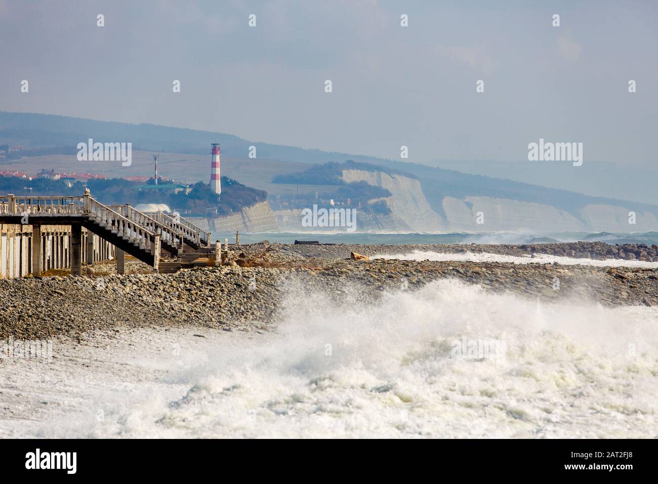 storm waves on the background of the lighthouse and high cliffs. In the ...