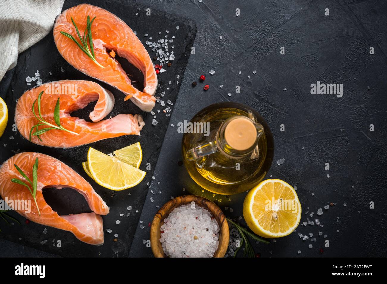 Raw salmon steak on black top view Stock Photo - Alamy