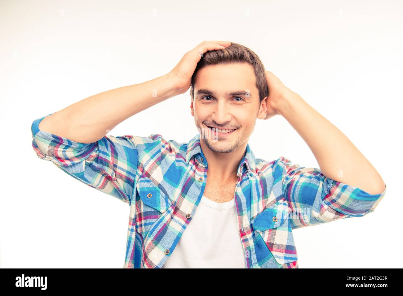 Handsome young man holding hands on his hair Stock Photo - Alamy