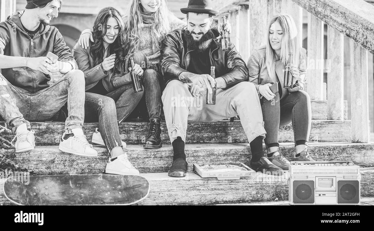 Young friends drinking beer and eating pizza outdoor in city center ...