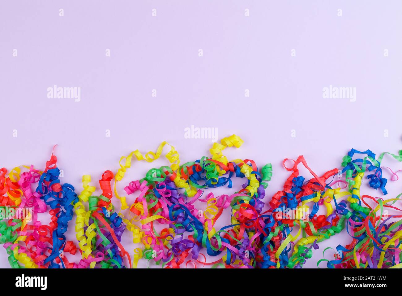 Festive party border or frame of colorful spiral streamers on pink ...