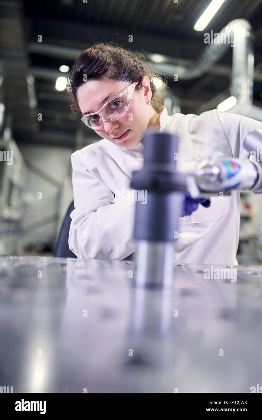 Female laboratory assistant in white coat with 3D printer on bokeh ...