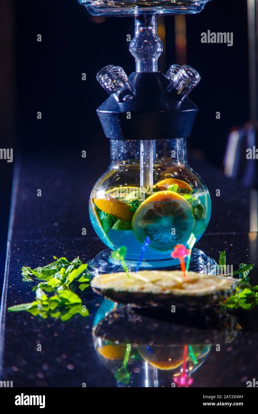 The hookah flask is round and transparent, filled with blue-green ...